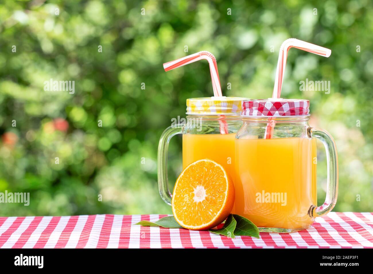 Two jars of orange juice and half an orange Stock Photo - Alamy