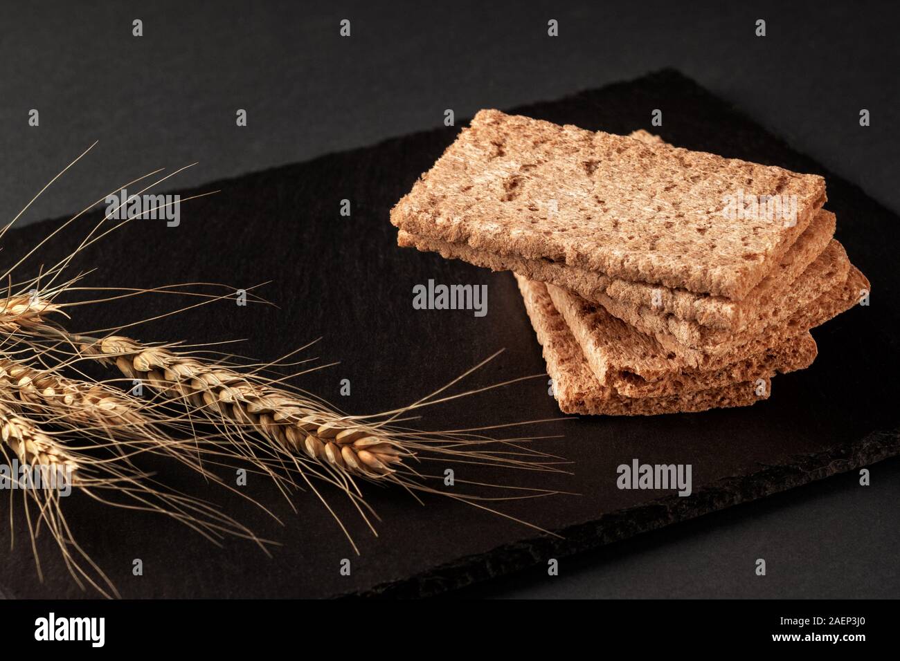 Crispy rye bread on a serving board with rye ears Stock Photo - Alamy