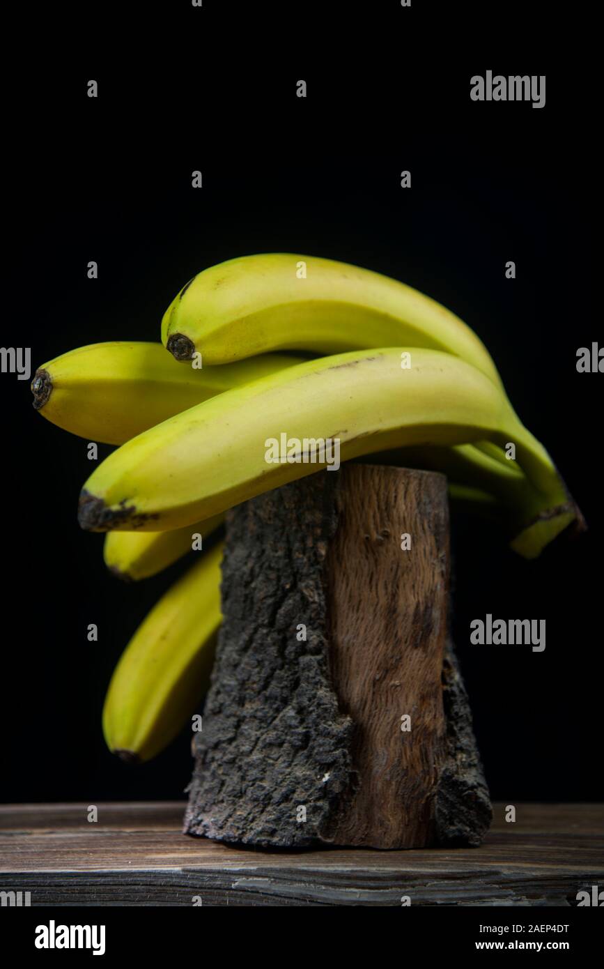 bananas on a wooden log Stock Photo - Alamy