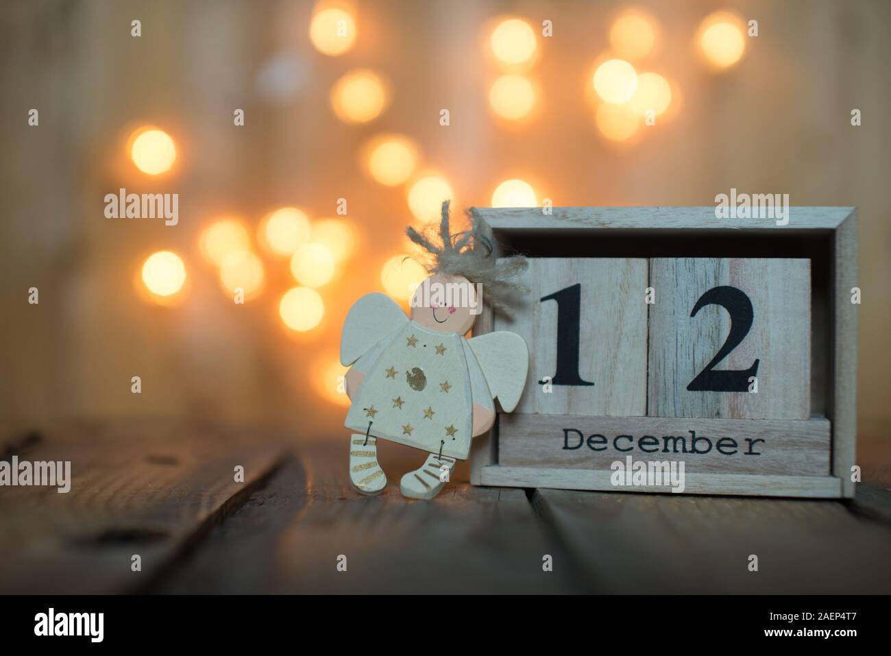 Cube wooden calendar showing date on 12th December with Angel over ...