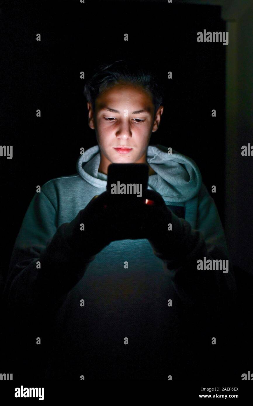 Teenager using a smartphone, sending a message. Teenager using his two ...