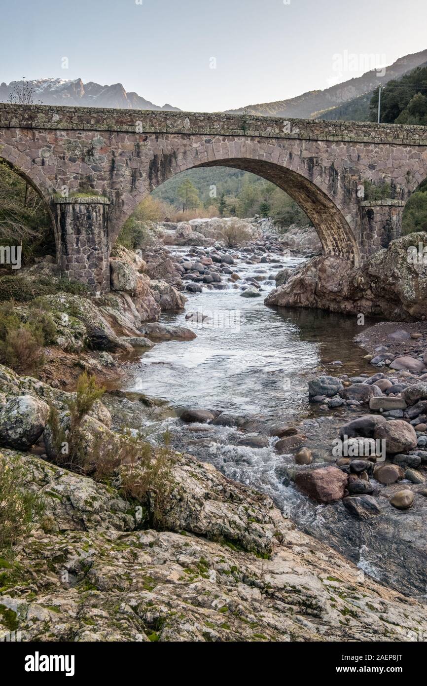 Stone bridge over the Fango river at Manso in Corsica as it cascades ...