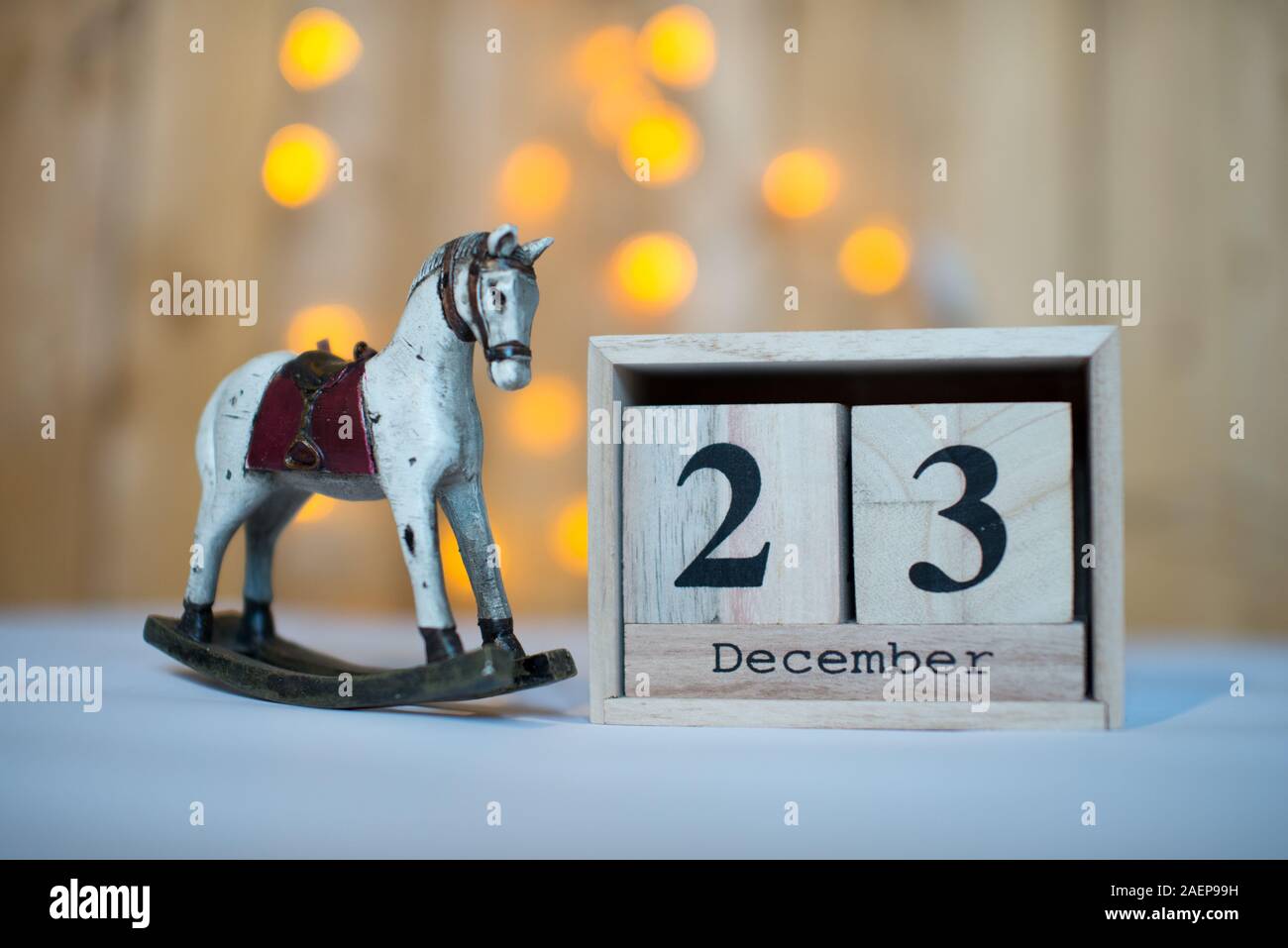 Cube wooden calendar showing date on 23th December with old toy rocking ...