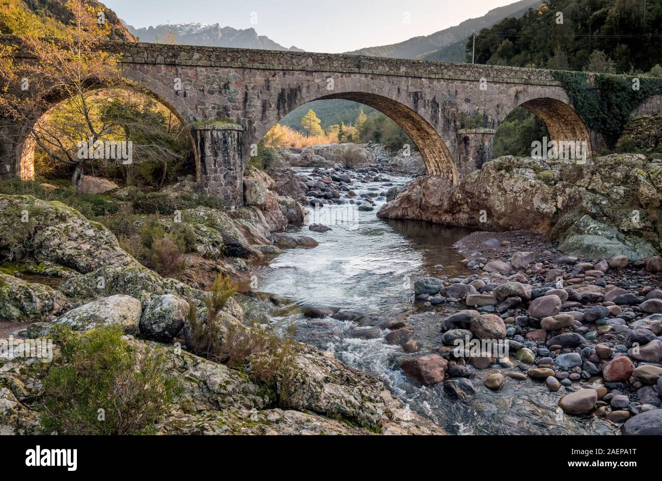 Stone bridge over the Fango river at Manso in Corsica as it cascades ...