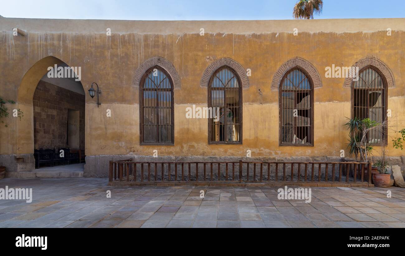 Row of four adjacent wooden grunge arched window with decorated wrought ...