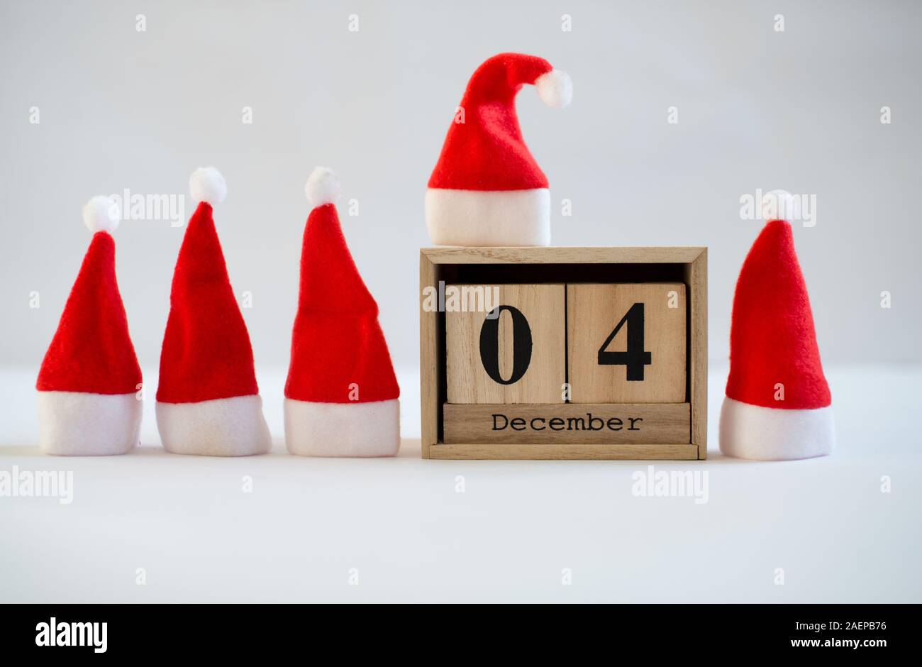 Cube wooden calendar showing date on 4th December with small Santa hats ...