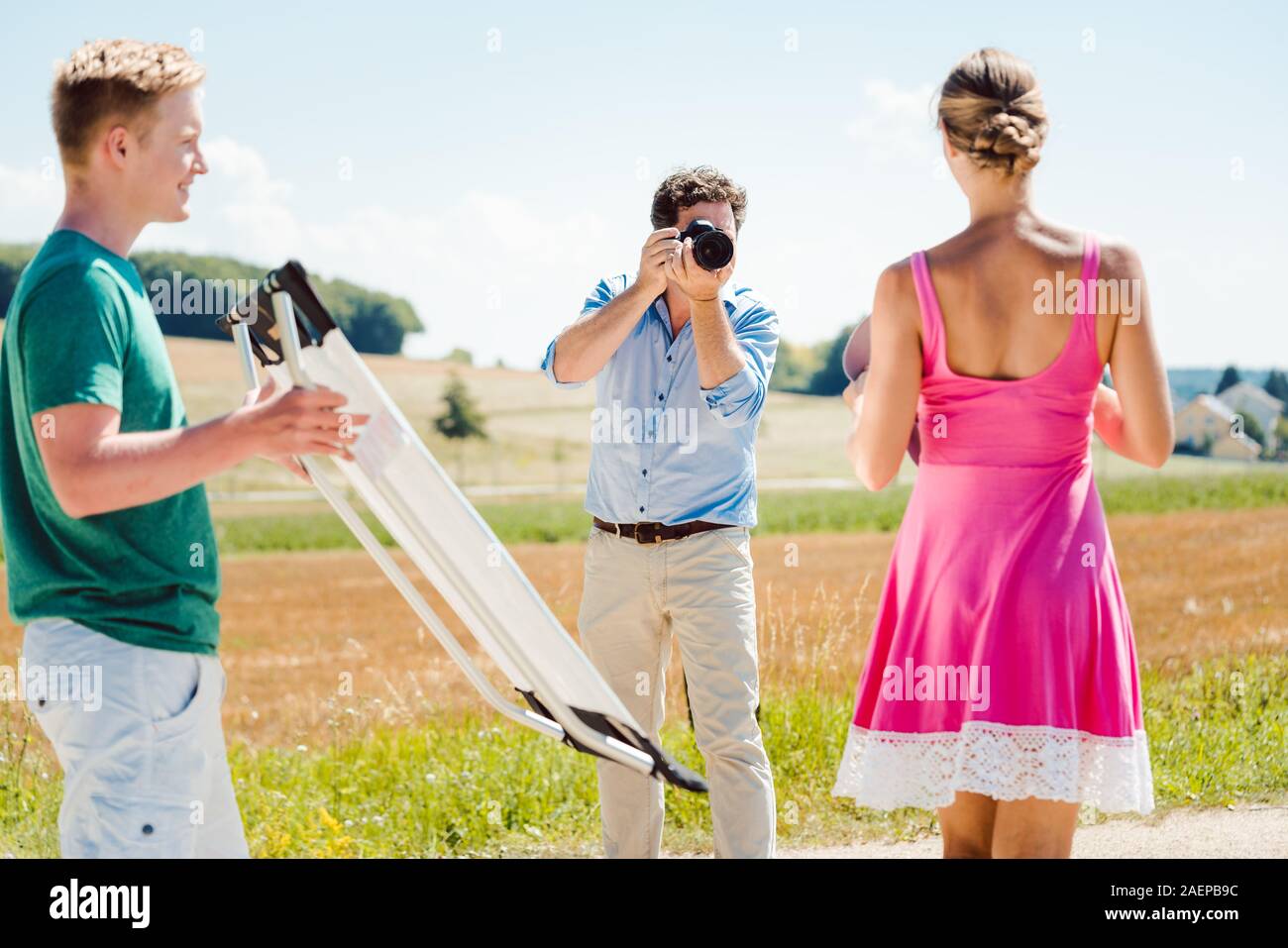 Photographer, model, and assistant on set during a photo shoot Stock ...