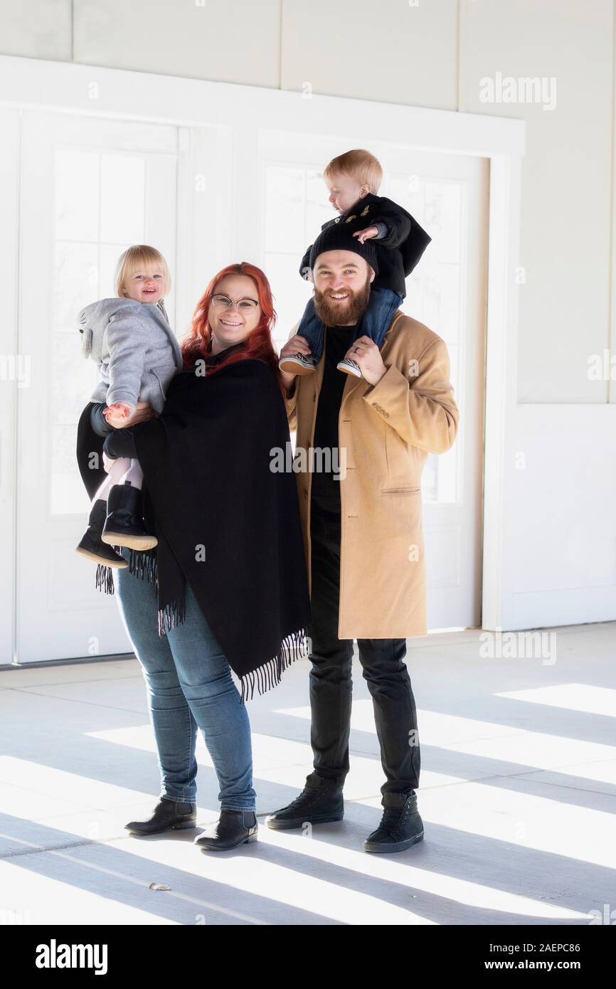 Millennial Family of Four with Two Young Children, Dressed in Warm ...