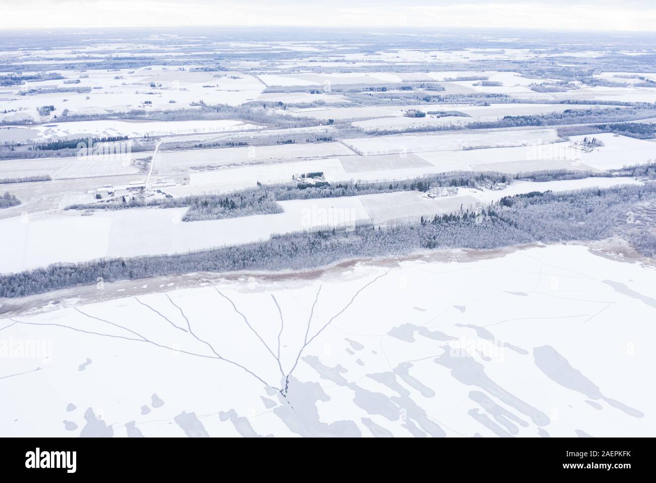 Aerial drone view of a partially frozen lake with unfrozen patches and ...