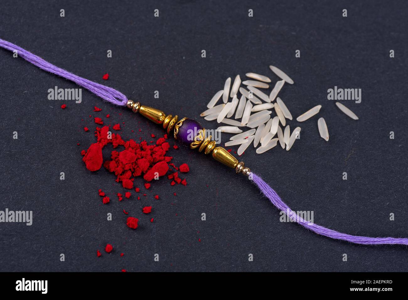 Raksha Bandhan : Rakhi with rice grains and kumkum on black background ...