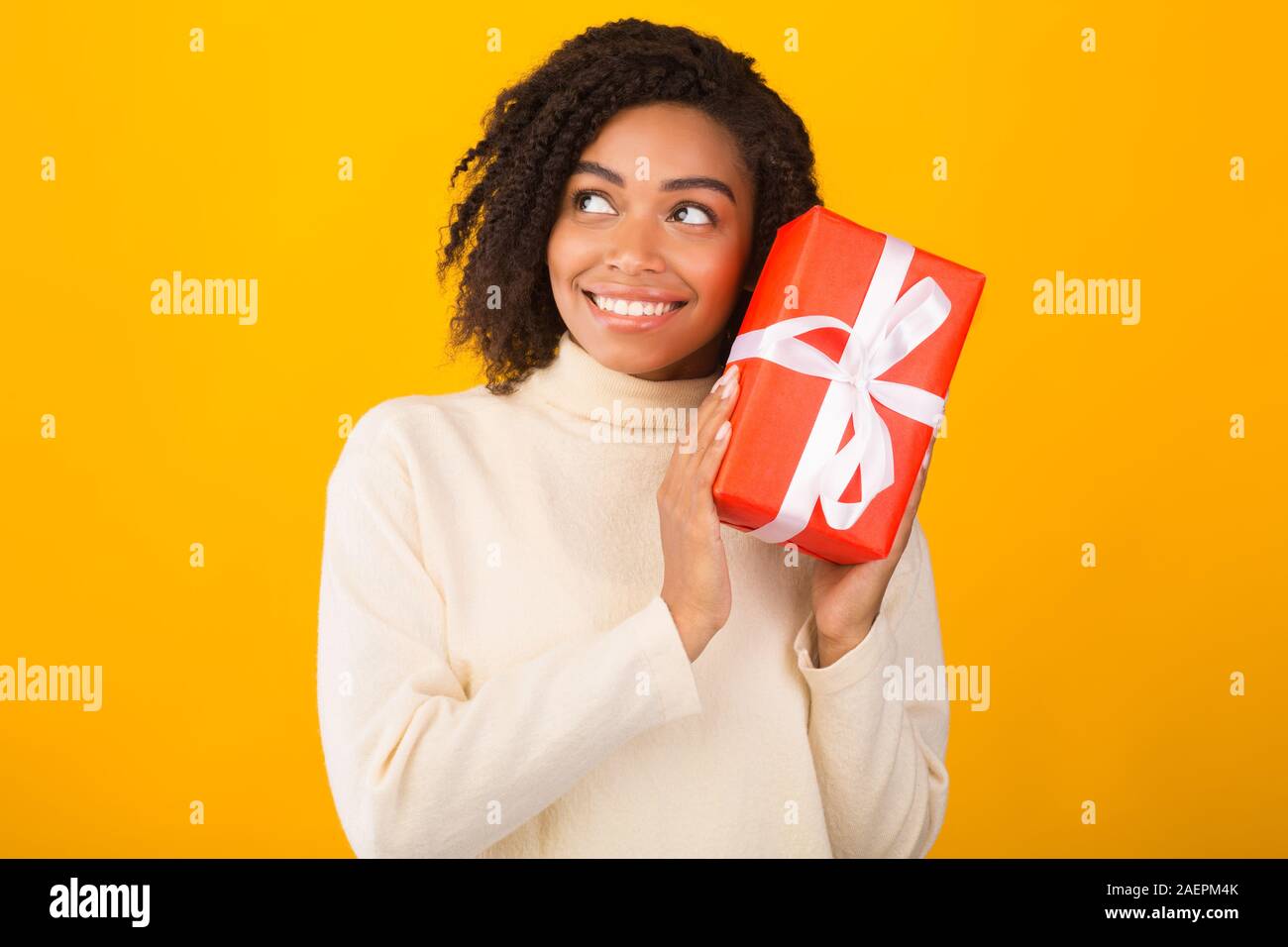 Woman shaking gift box hi-res stock photography and images - Alamy