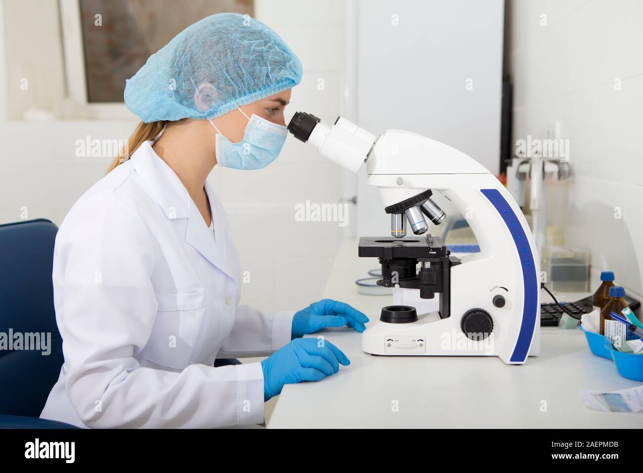 Young woman in medical clothes working with microscope Stock Photo - Alamy