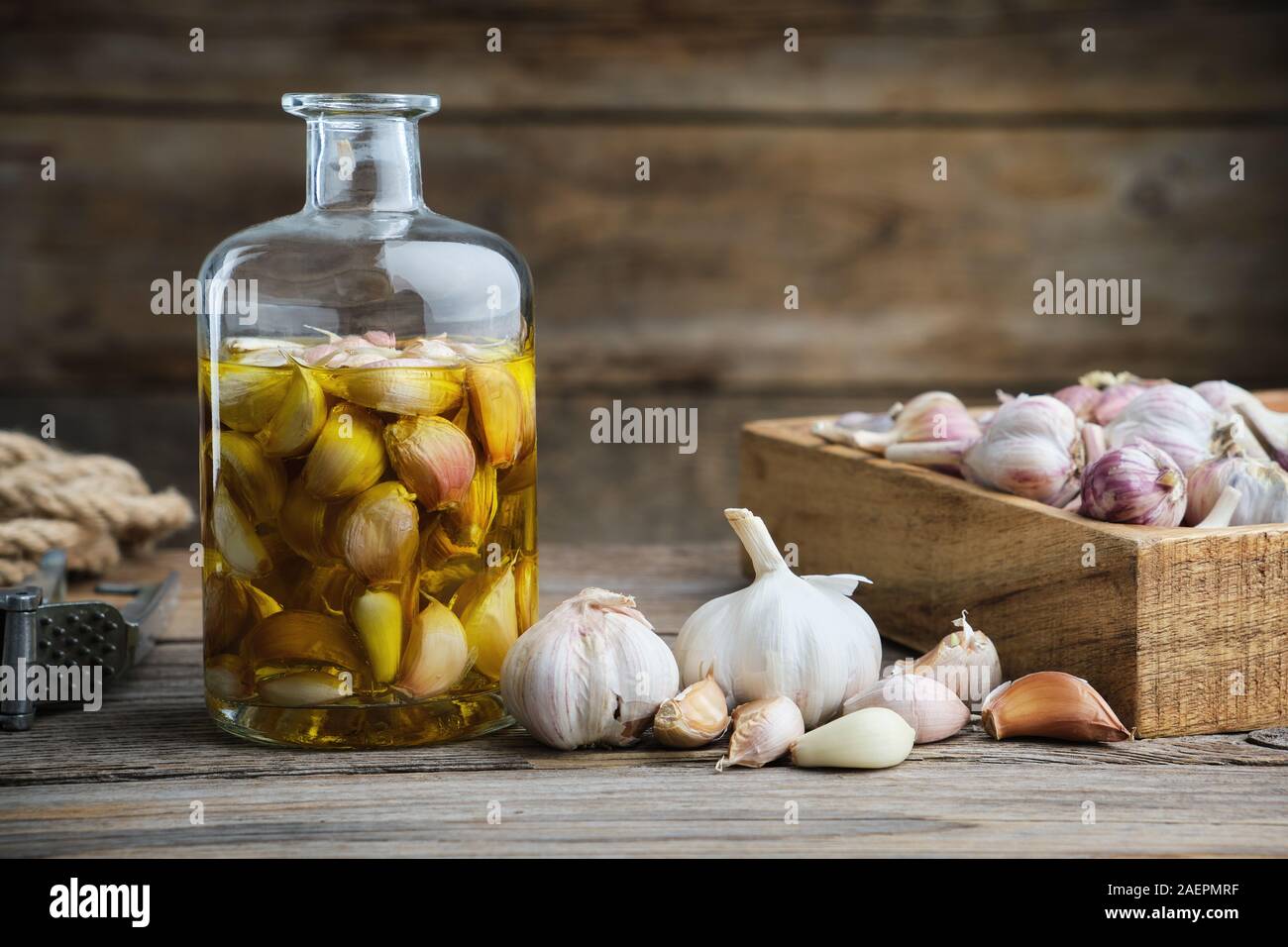 Garlic aromatic flavored oil or infusion bottle, wooden crate of garlic ...
