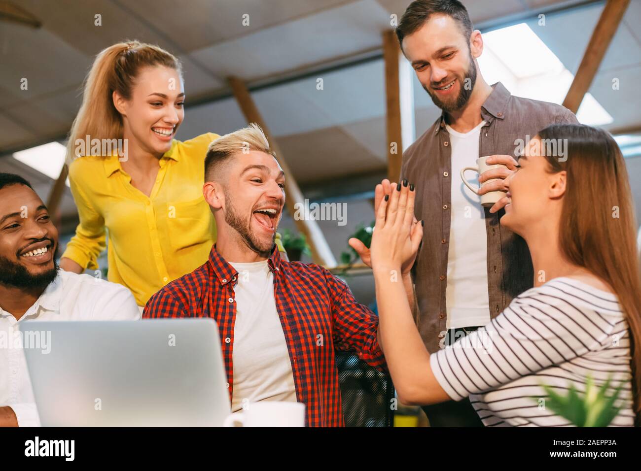 Success. Young colleagues giving high five and smiling Stock Photo - Alamy