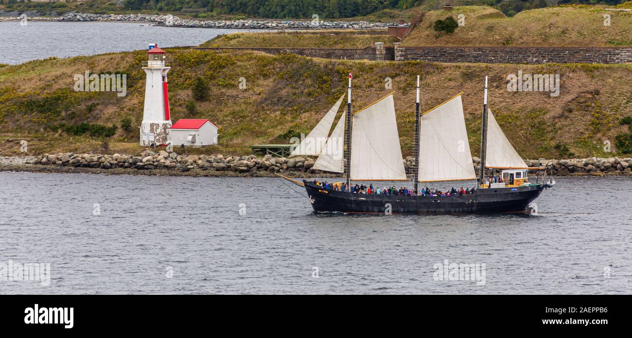 Schooner Past Small Lighthouse and Shed Stock Photo - Alamy