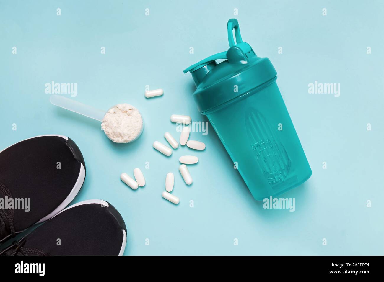 Protein powder in a spoon, shaker, sneakers and diet sport supplement ...