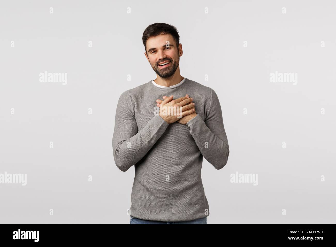 Touched and moved to tears charming, bearded male in grey sweater ...