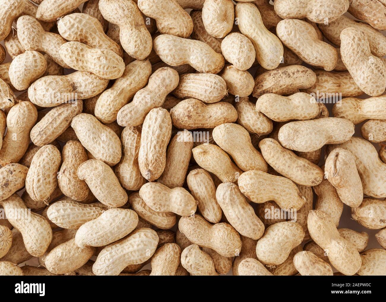 Raw unpeeled peanuts background Stock Photo - Alamy
