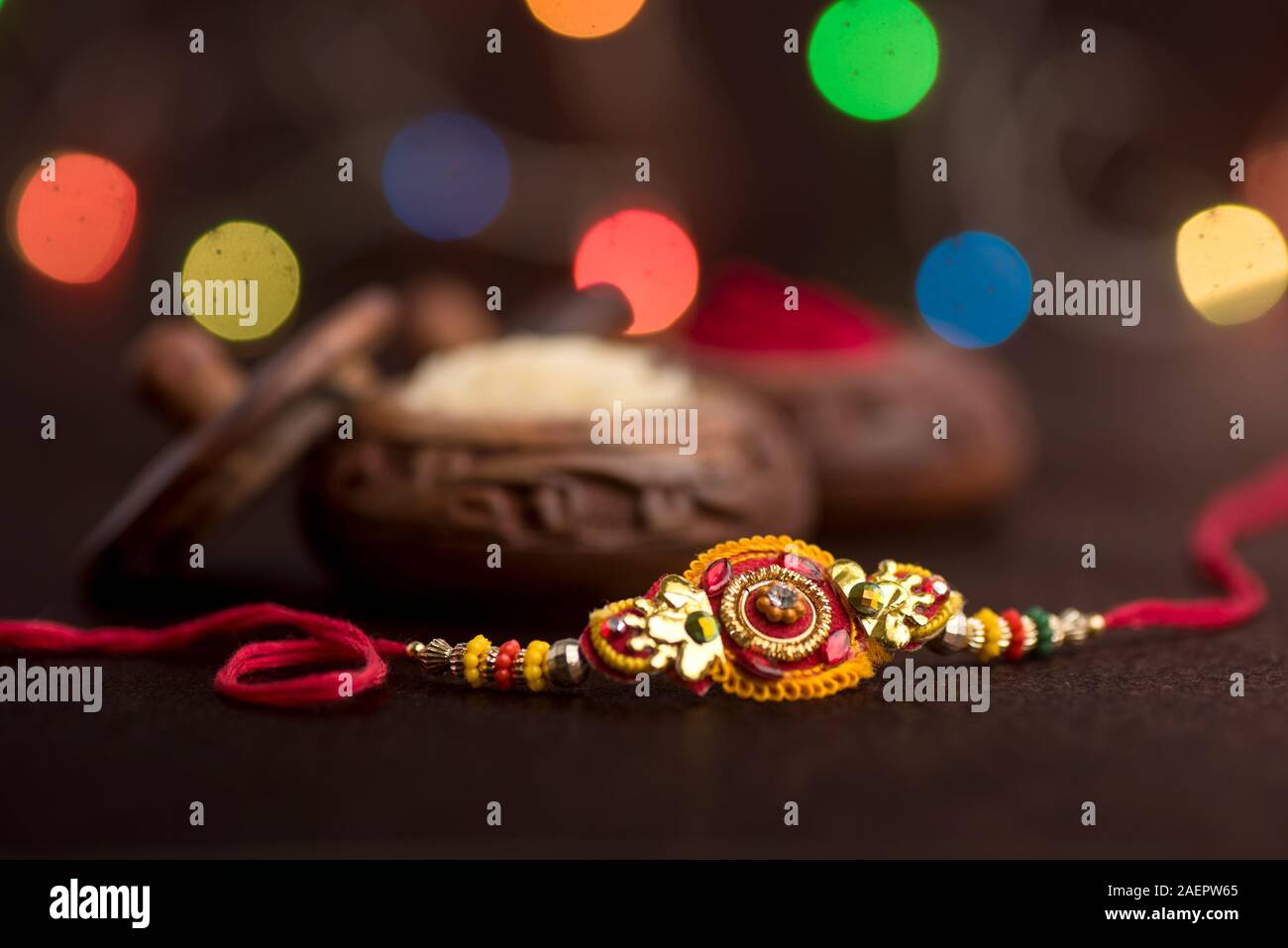 Raksha Bandhan background with an elegant Rakhi, Rice Grains and Kumkum ...