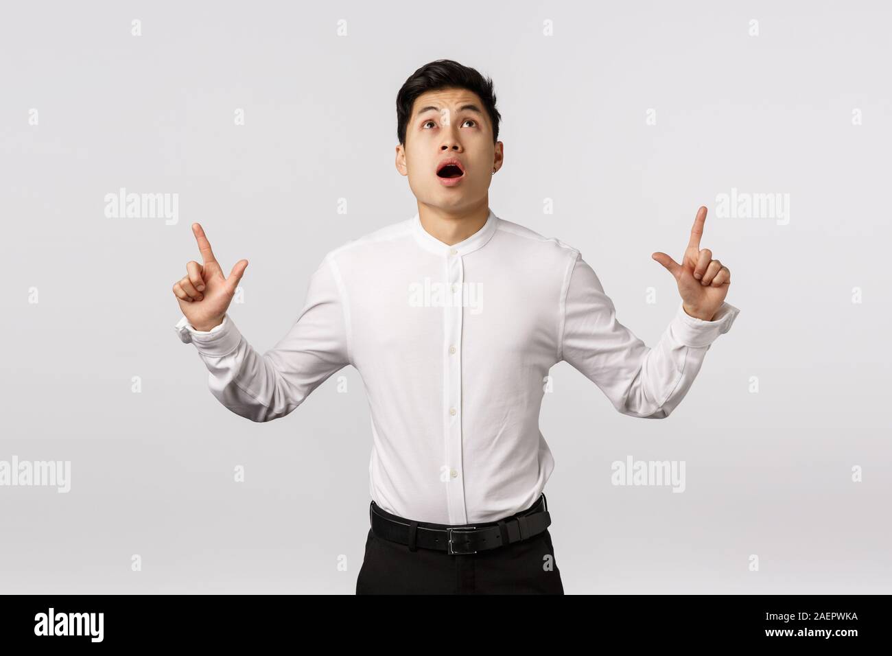 Shocked and scared worried asian businessman see something falling down ...