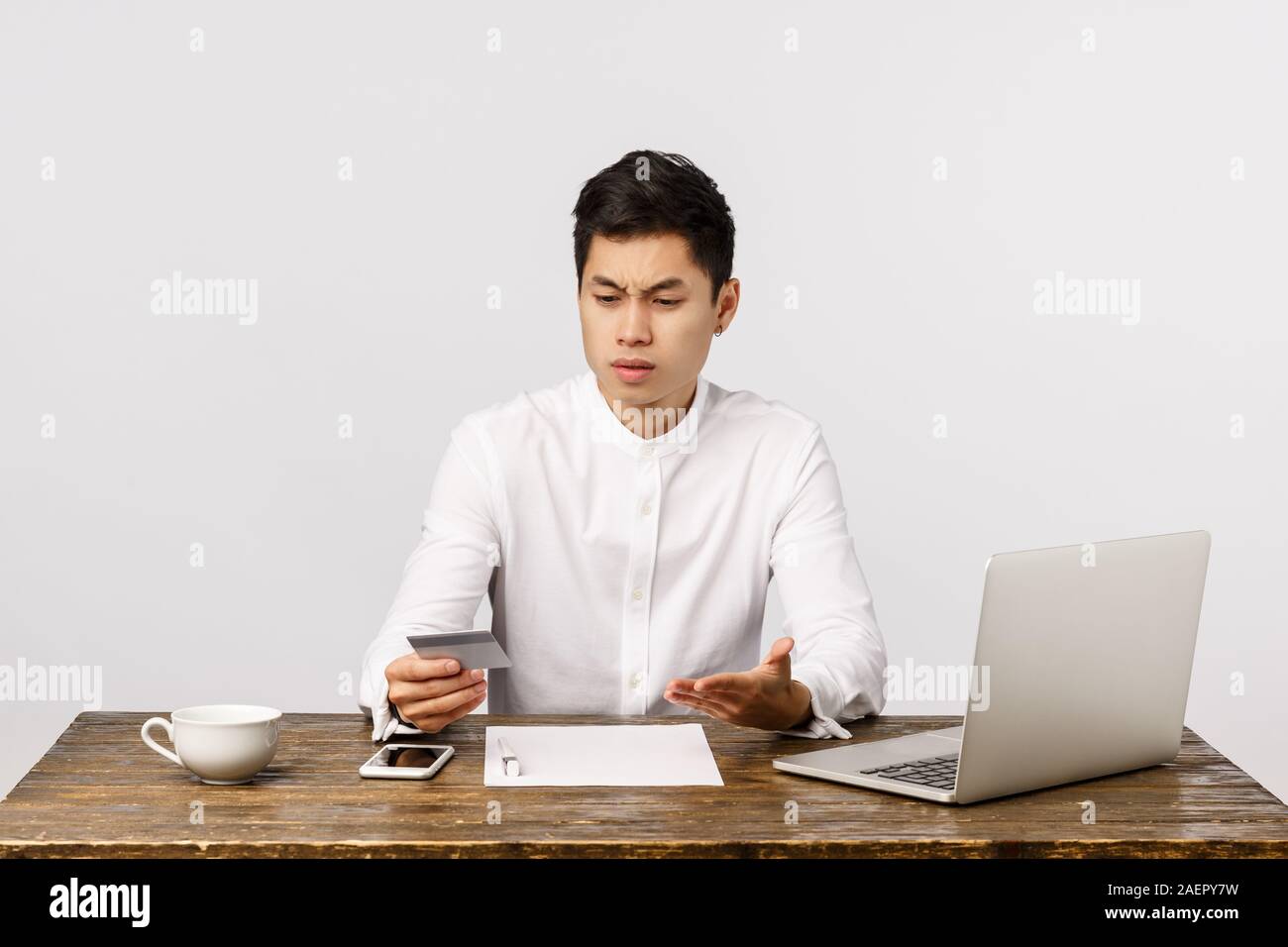 Distressed questioned and frustrated young asian guy sitting office at ...