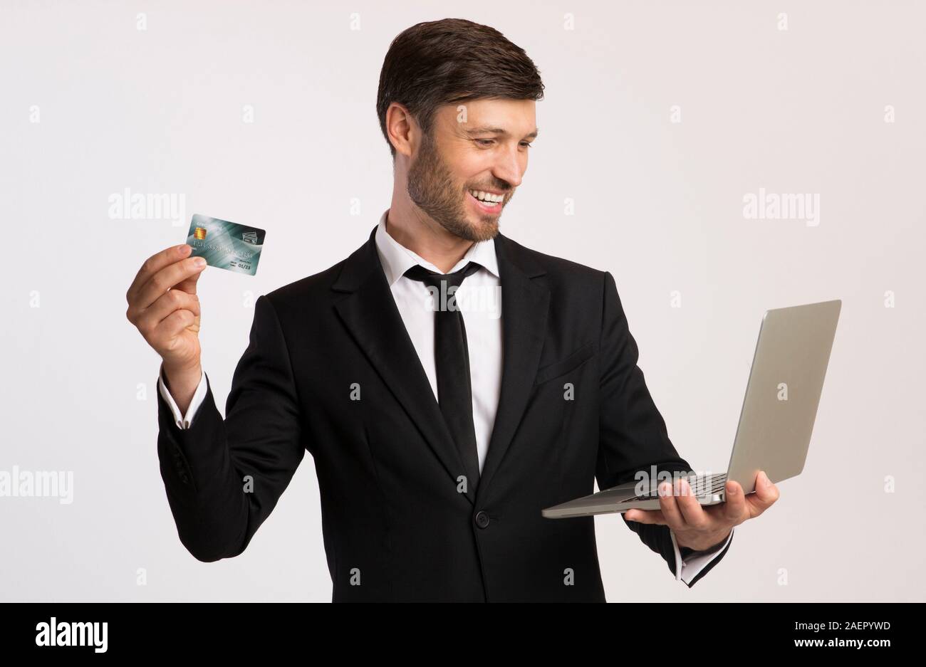 Business guy holding laptop and credit card over white background Stock ...