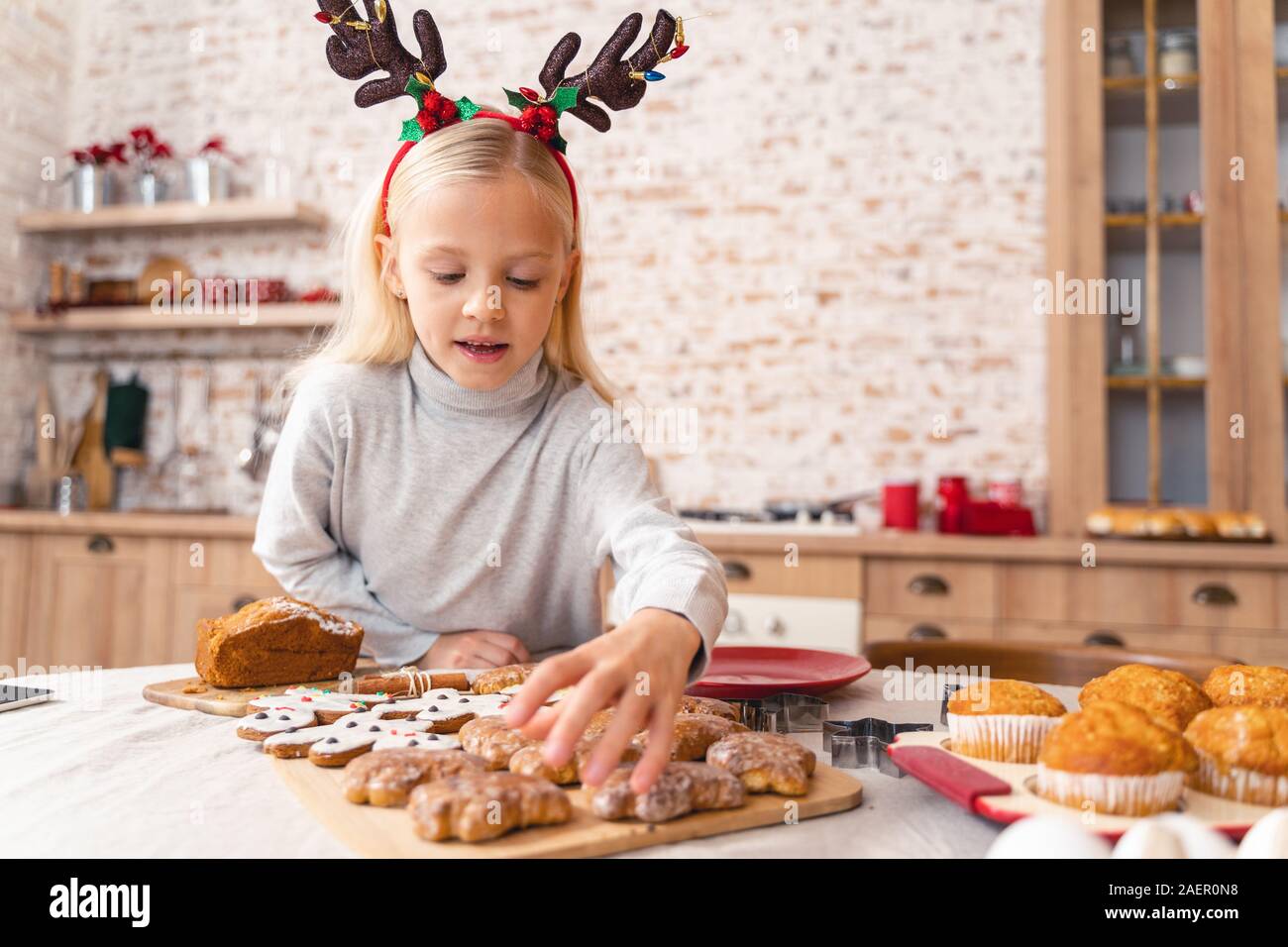 Little girl leaning over the kitchen table Stock Photo - Alamy
