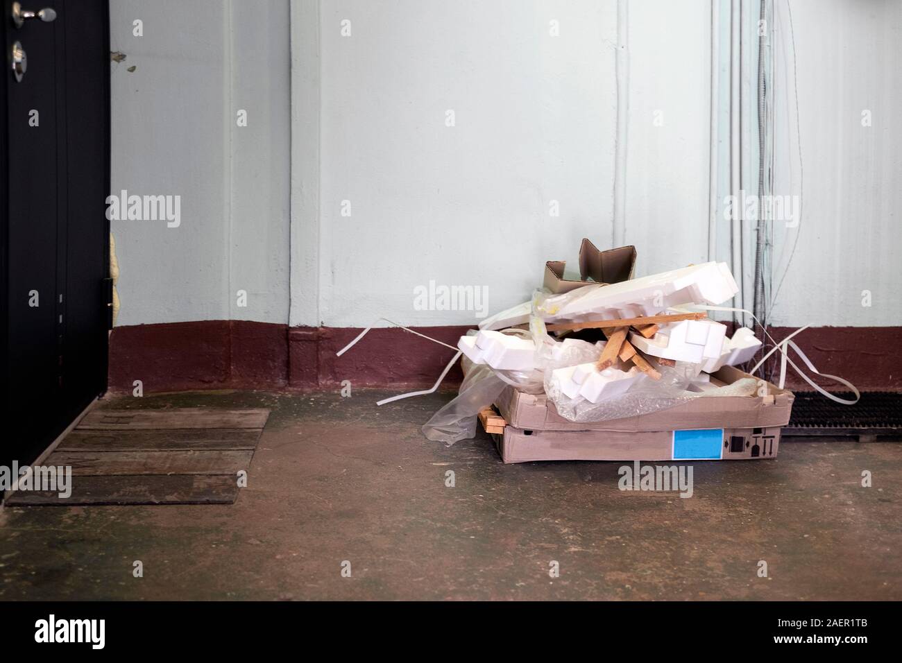 Garbage abandoned on a floor next to apartment door Stock Photo - Alamy