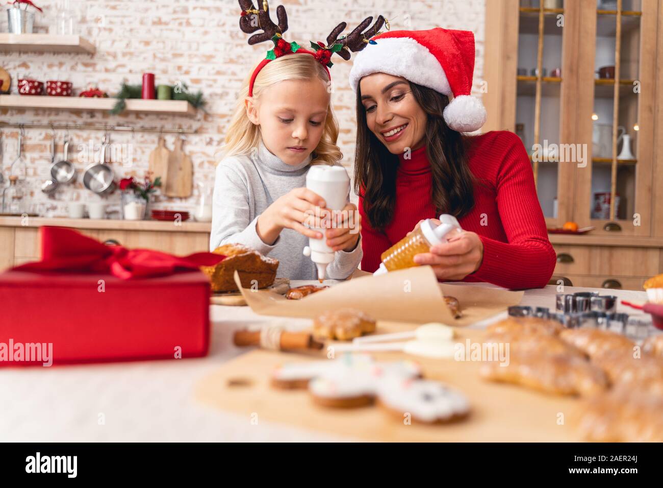 Woman and a girl using icing squeeze bottles Stock Photo - Alamy