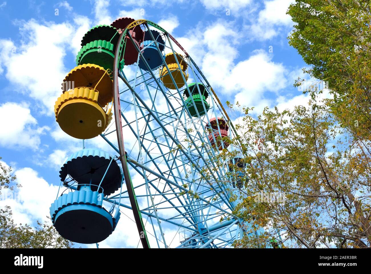 Ferris Wheel against trees and the sky with clouds Stock Photo - Alamy