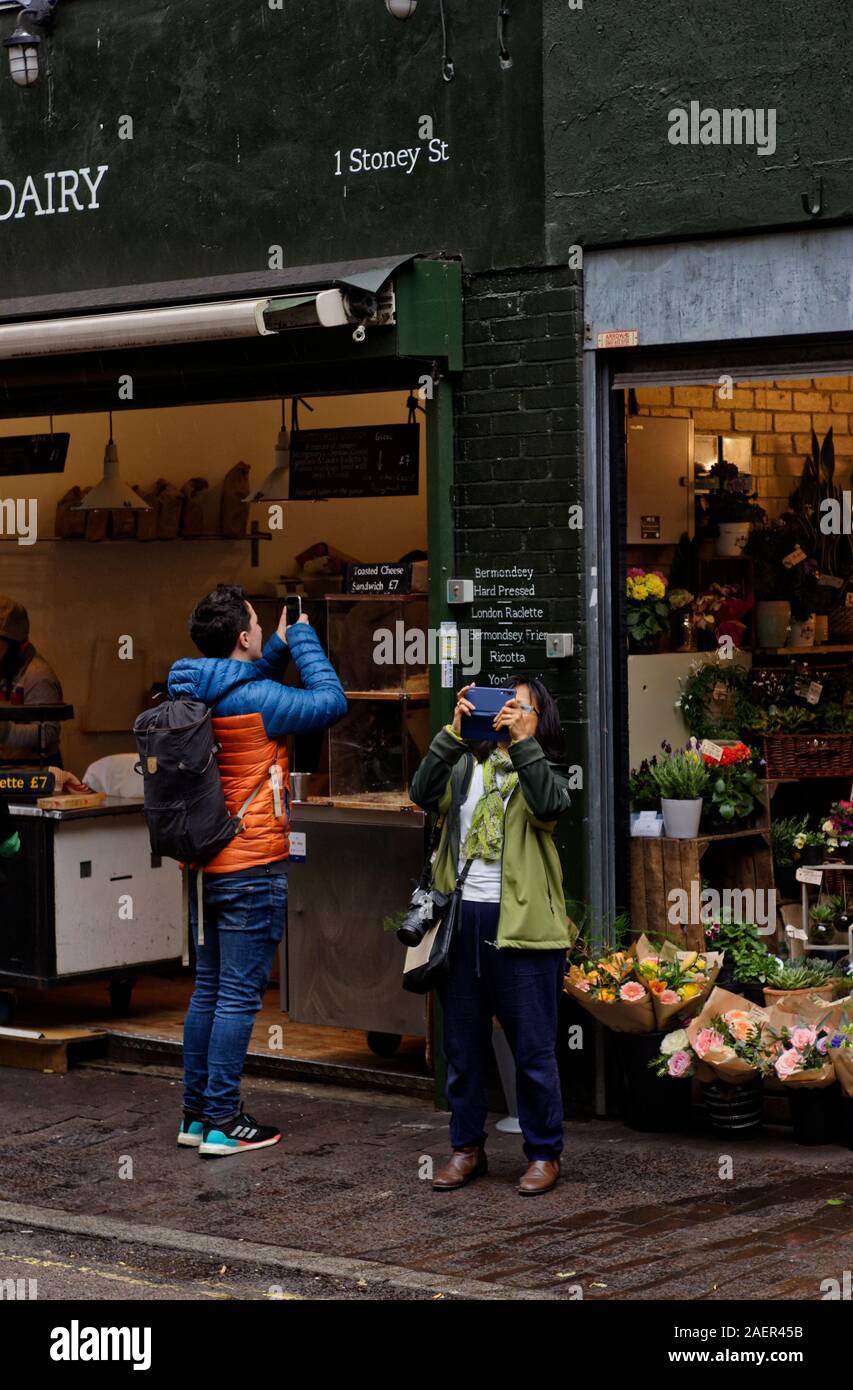 Two photographers, with camera and phone, Borough Market, London Stock ...