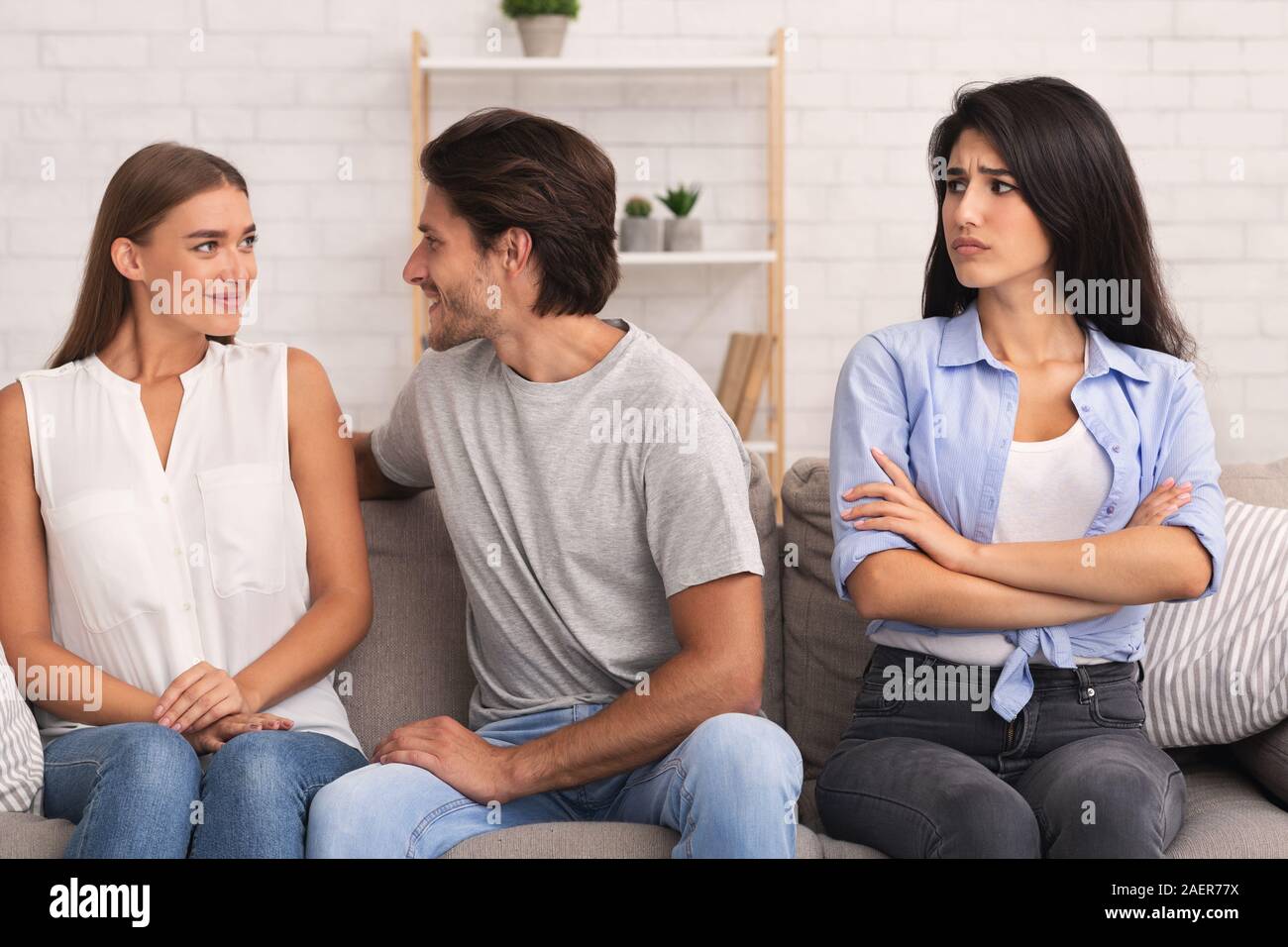Girl Looking At Boyfriend Flirting With Woman Sitting On Sofa Stock ...