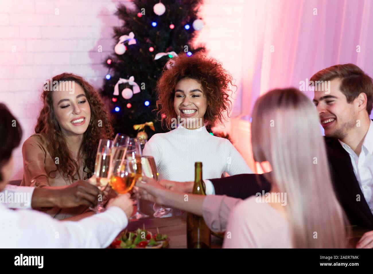 Young People Celebrating Christmas Sitting At Celebratory Table At Home ...
