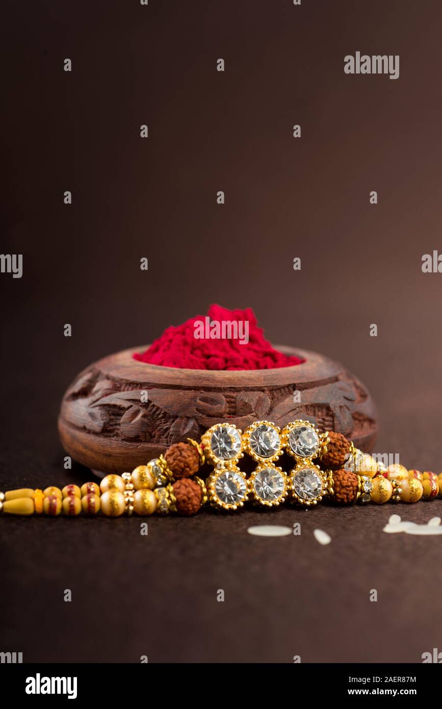 Raksha Bandhan background with an elegant Rakhi, Rice Grains and Kumkum ...