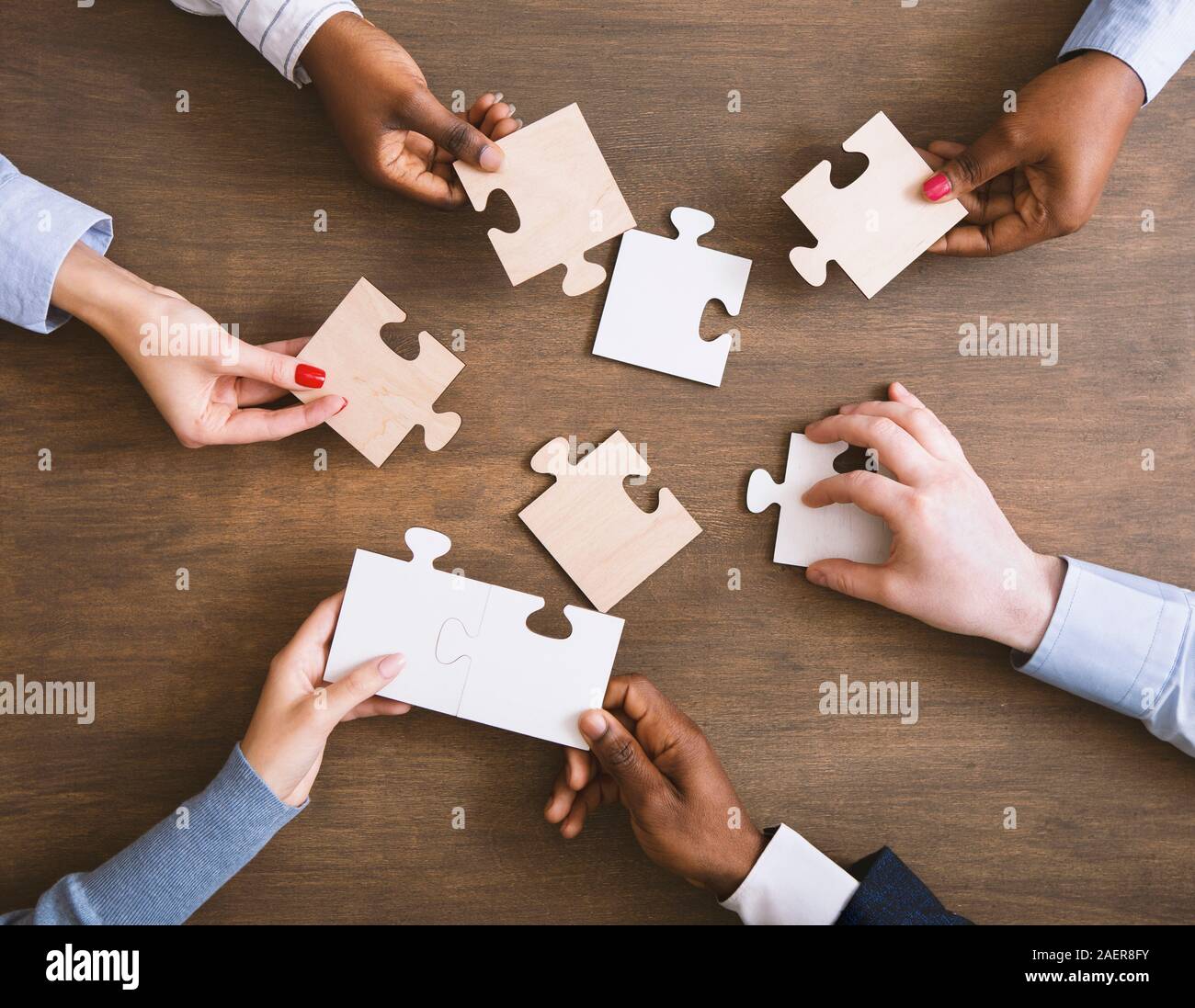 Group of business people assembling jigsaw puzzle together Stock Photo ...