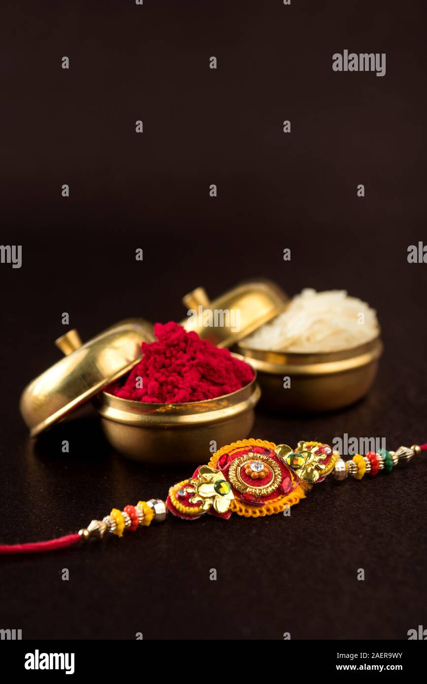 Raksha Bandhan background with an elegant Rakhi, Rice Grains and Kumkum ...