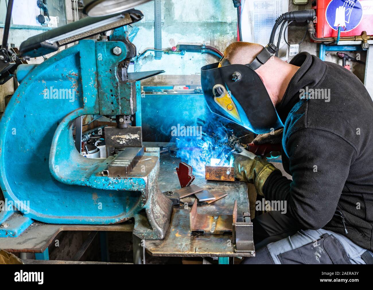 Electric welding process. Worker in welding mask. Bright white and blue ...
