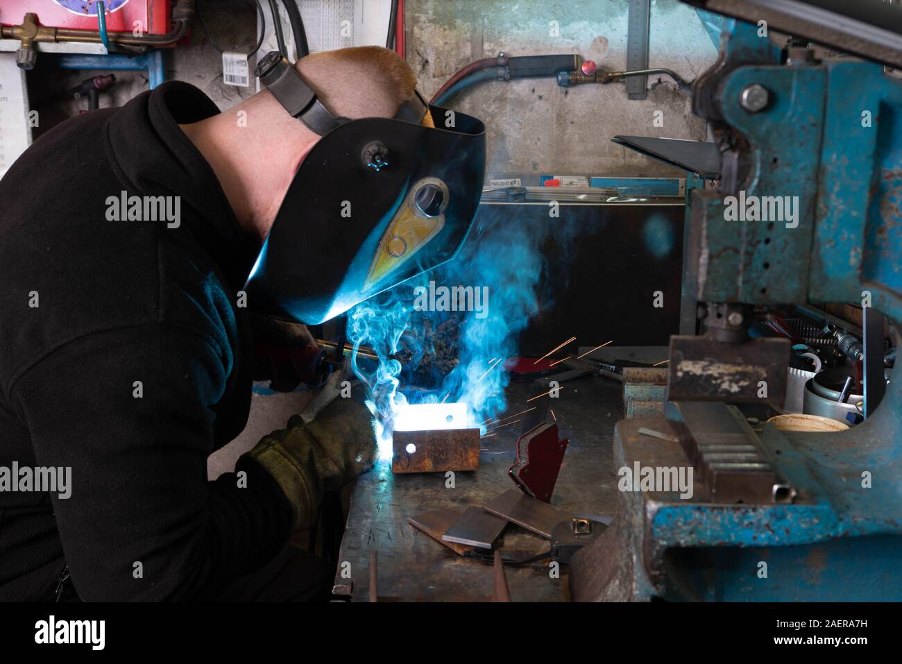 Electric welding process. Worker in welding mask. Bright white and blue ...