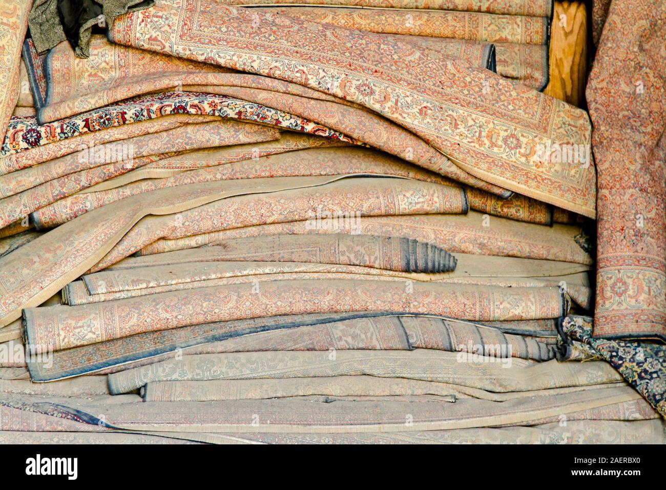 Big bunch of old Persian carpets in rolls Stock Photo - Alamy