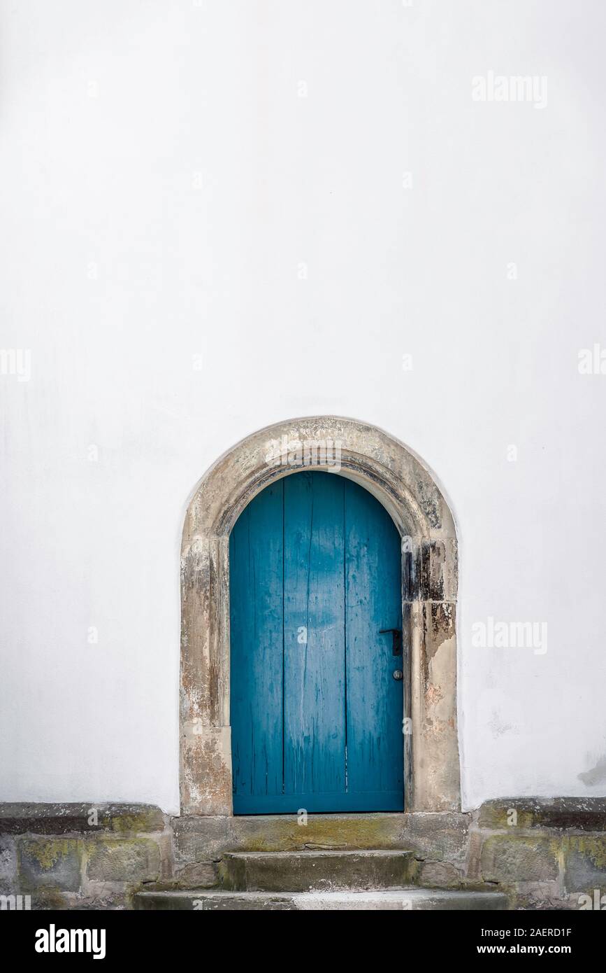 Medieval arched door. Aged wooden door in blue color with stone stairs ...