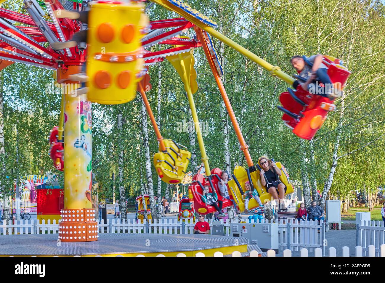 People ride the chain carousel in an amusement park. Cheboksary, Russia ...