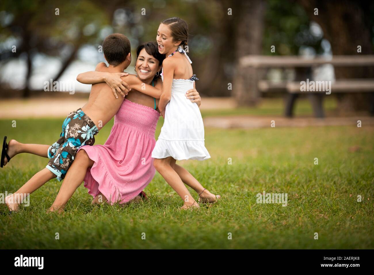Mother and children hugging in park Stock Photo - Alamy