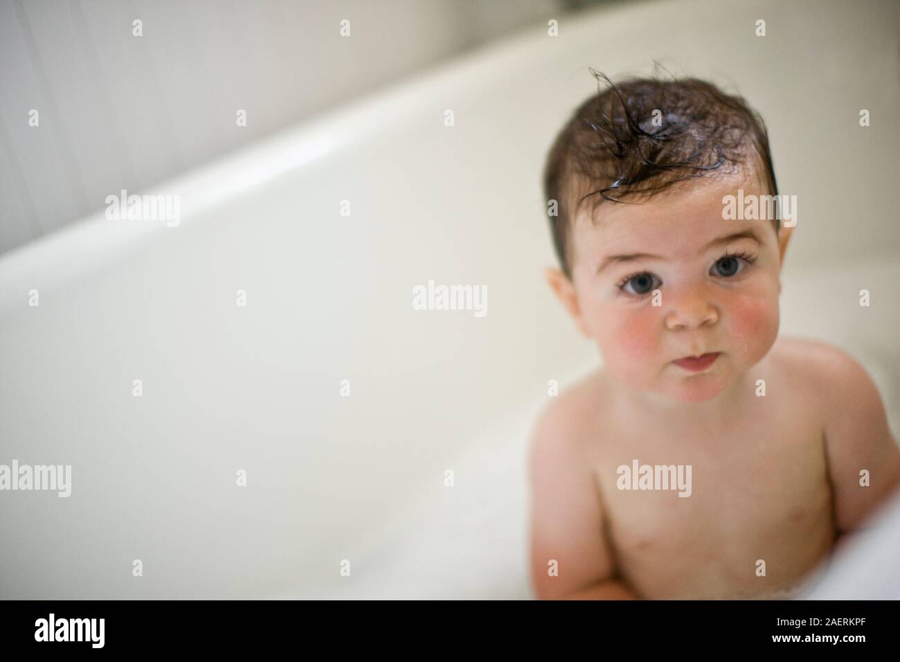 Baby boy sitting in a bath Stock Photo - Alamy