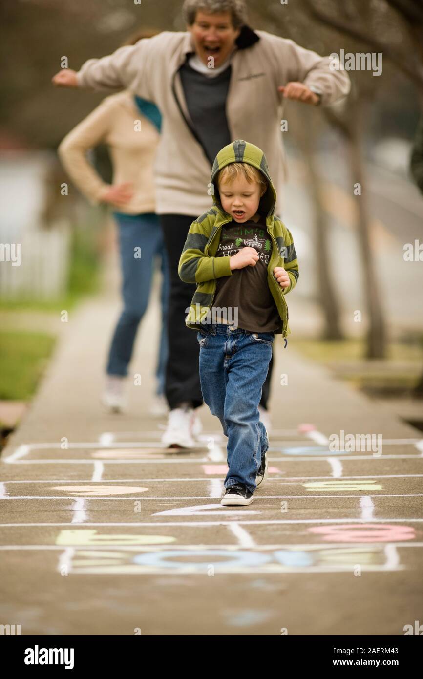 A young boy playing hopscotch with his grandmother Stock Photo - Alamy