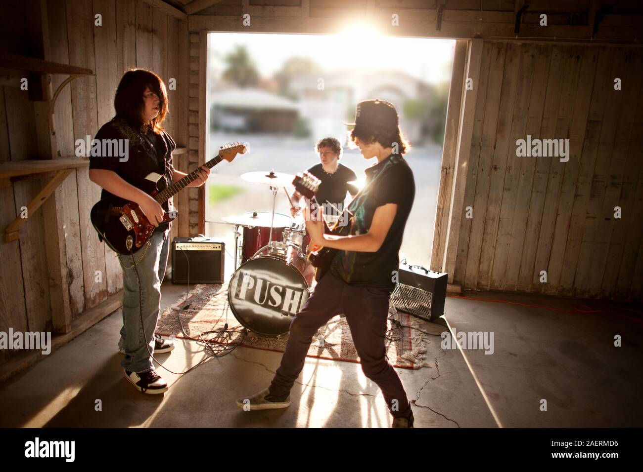 Three teenage boys playing instruments during band practice Stock Photo ...