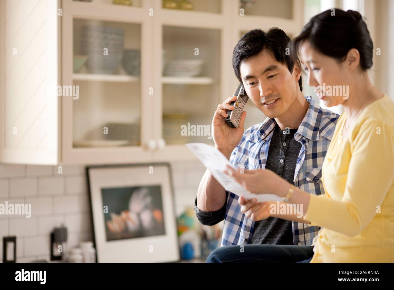Man helping his mother pay her bills over the phone Stock Photo - Alamy