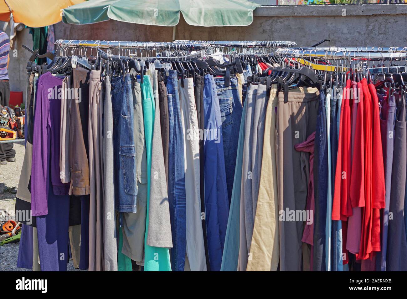 Pants and skirts hanging at clothes rails flea market Stock Photo - Alamy