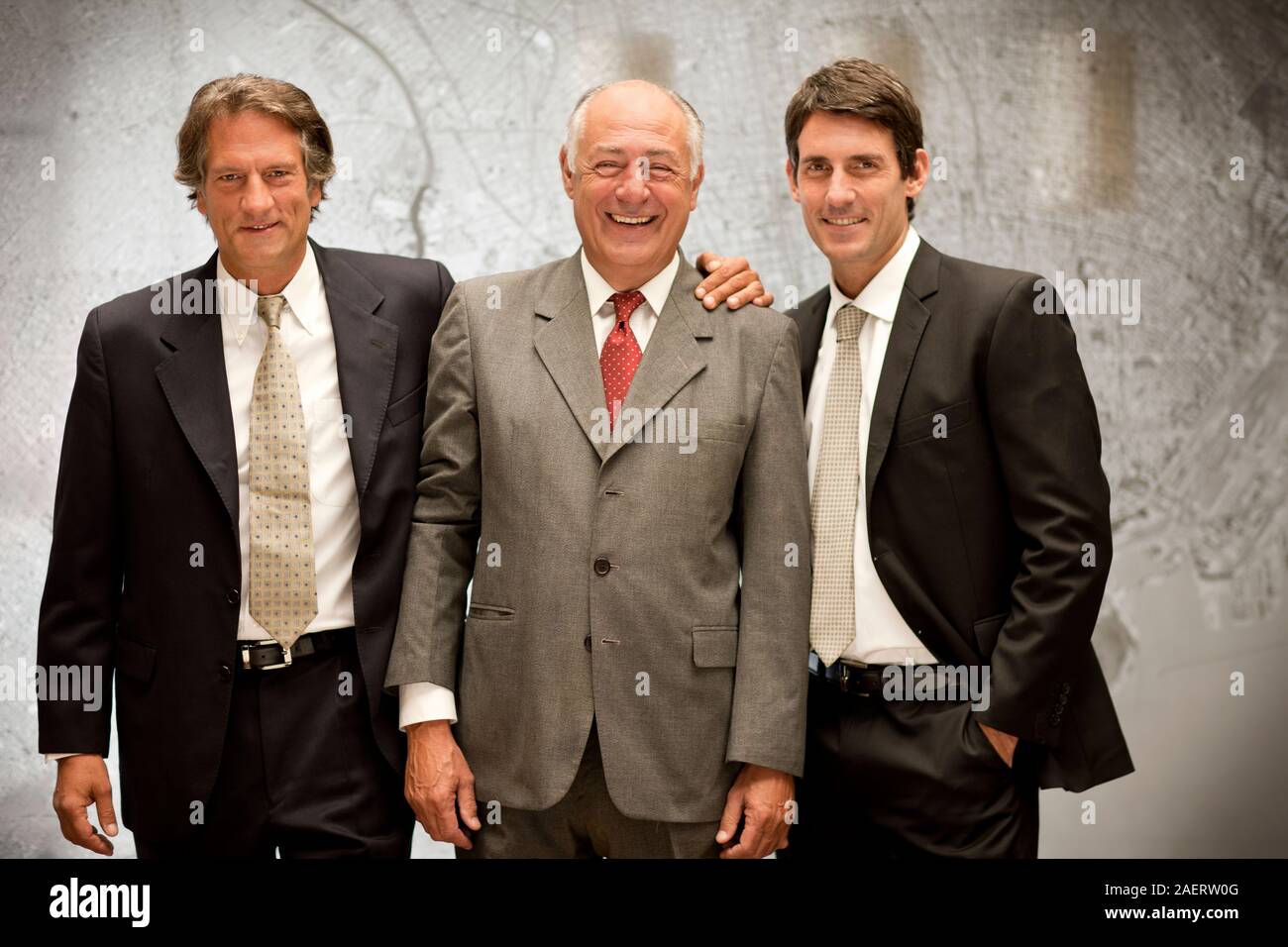 Three businessmen of different ages smile for a portrait Stock Photo ...