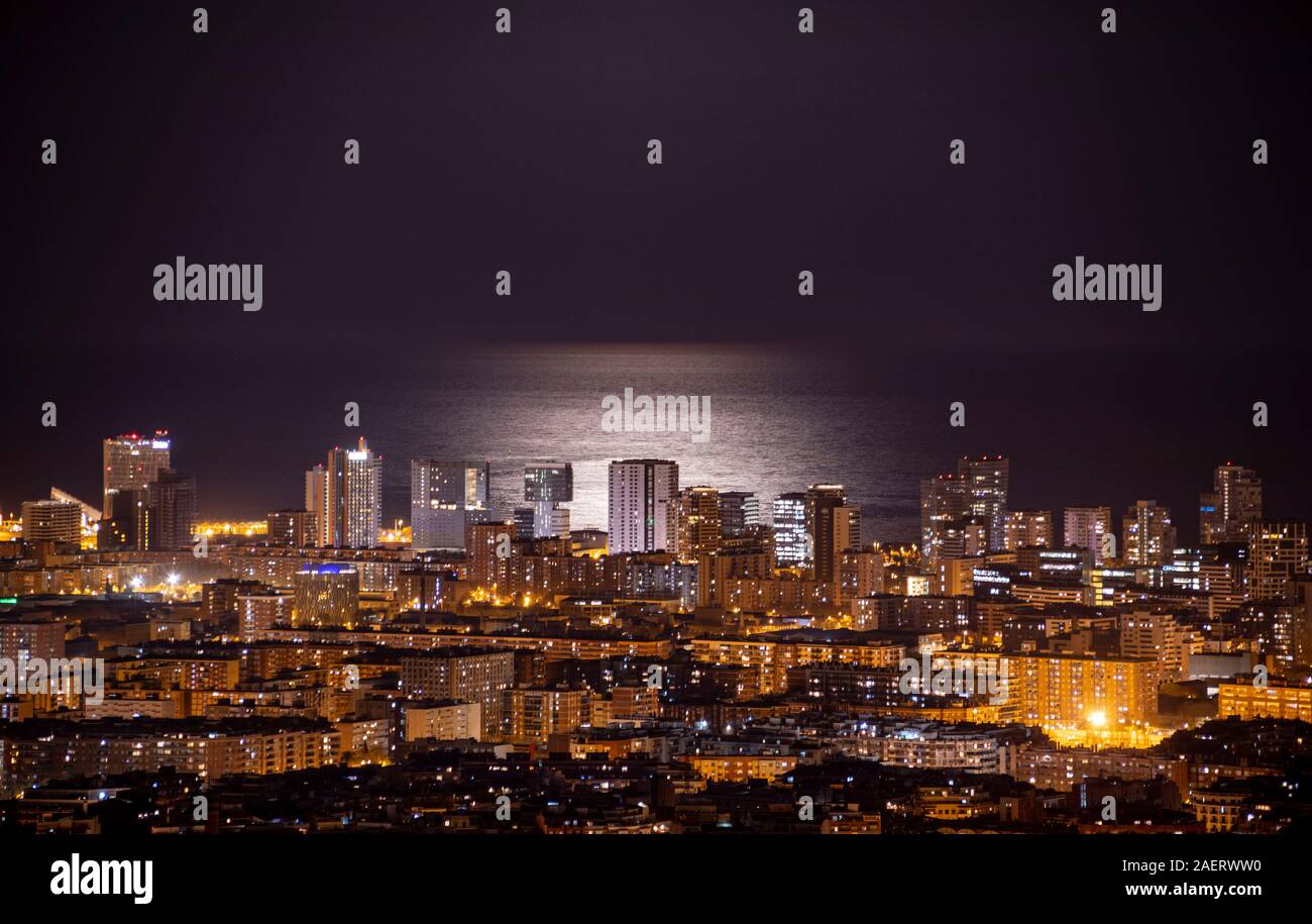 Barcelona skyline at night with the moon over the sea Stock Photo - Alamy