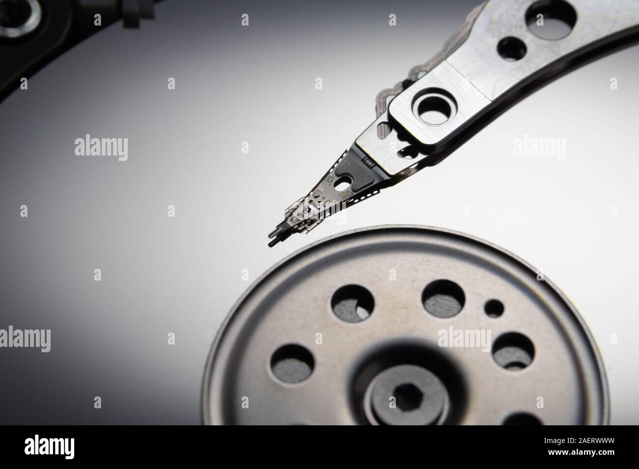 Open hard disk drive. The concept of data storage. Data array. Magnetic head on the surface of ...